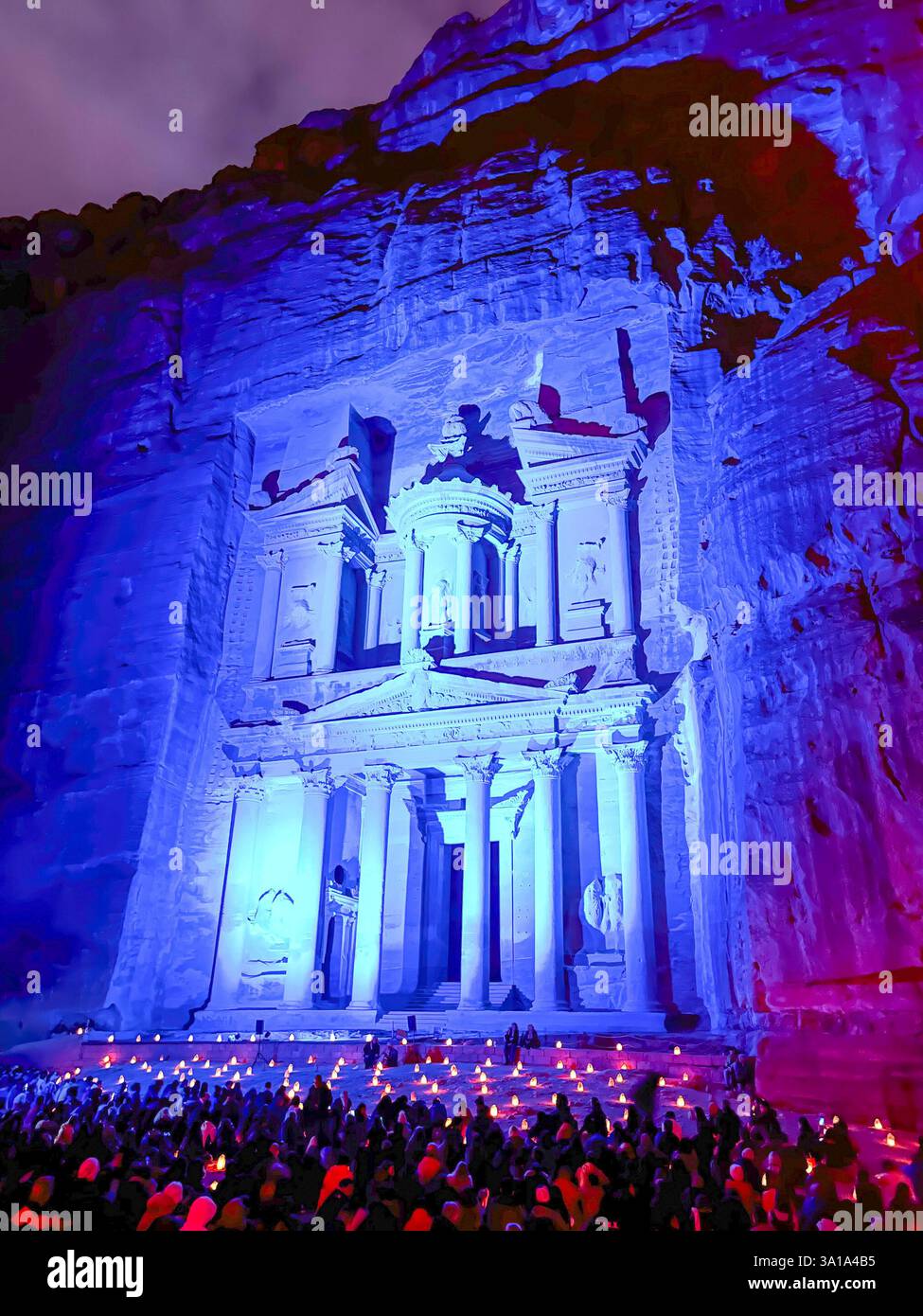 Large group of people sitting on the ground at night, the rock cut ...