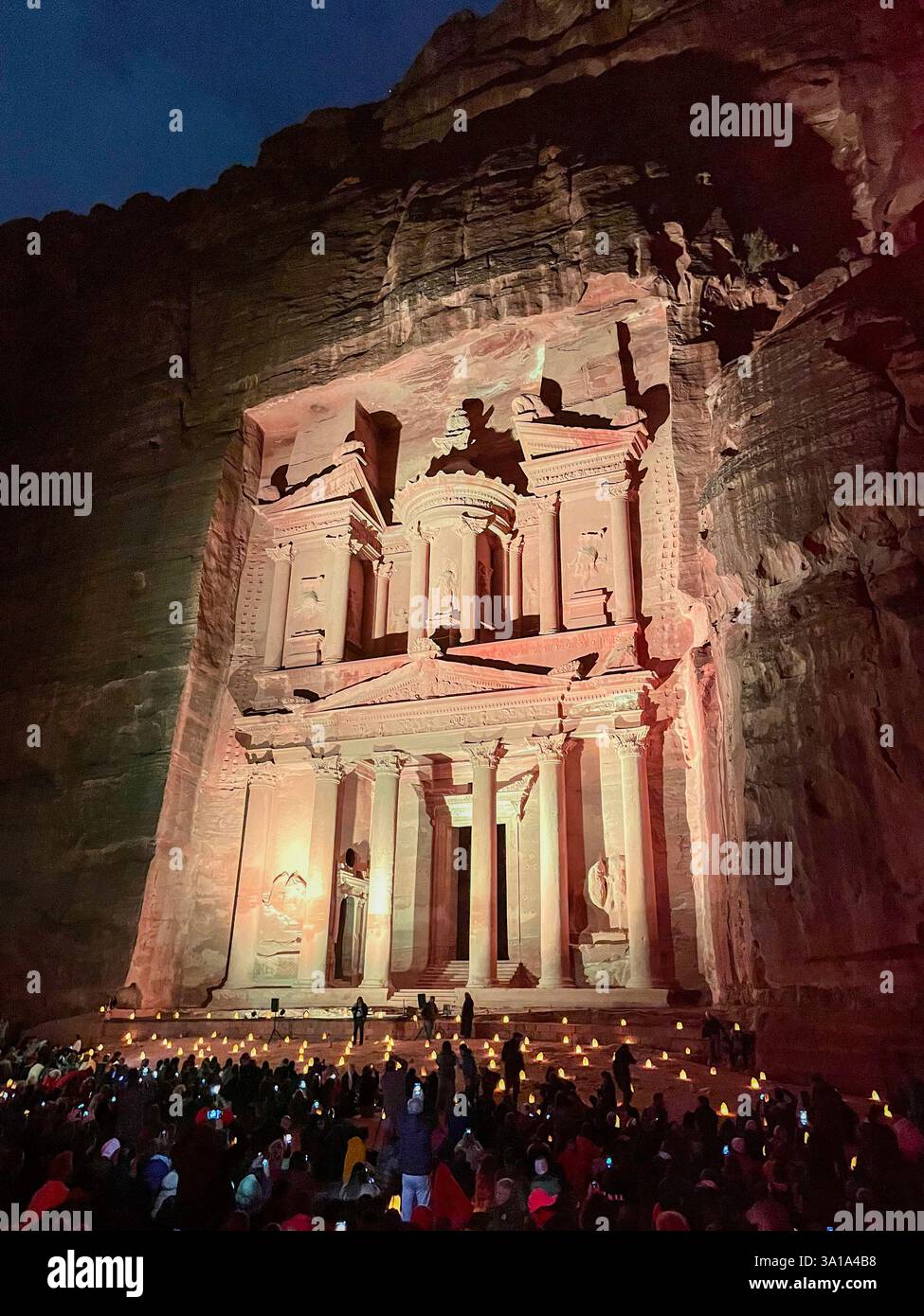 Large group of people sitting on the ground at night, the rock cut ...
