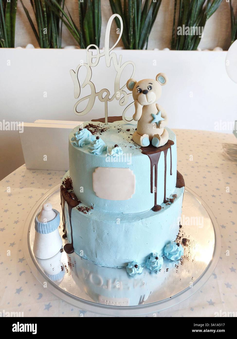 Two tier frosted blue baby shower cake decorated with chocolate and a ...