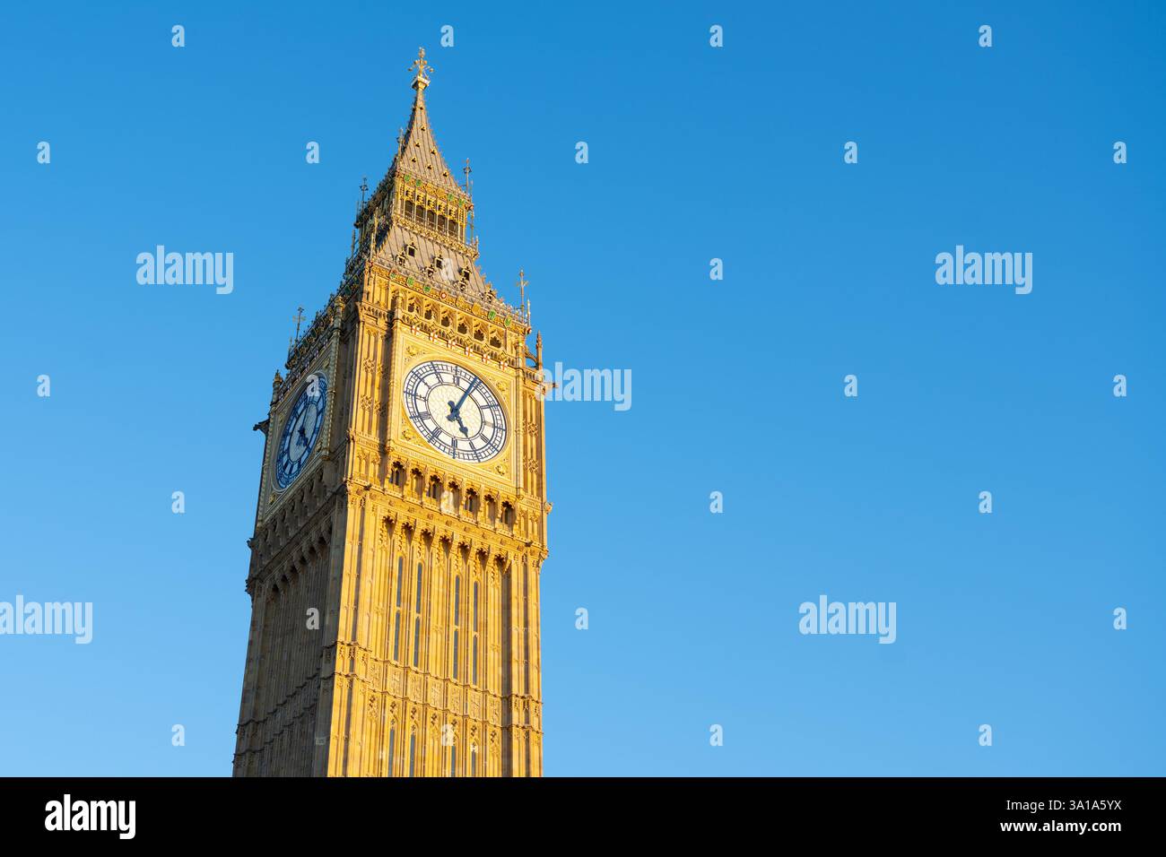 Big Ben towers majestically against a bright blue sky. This iconic ...