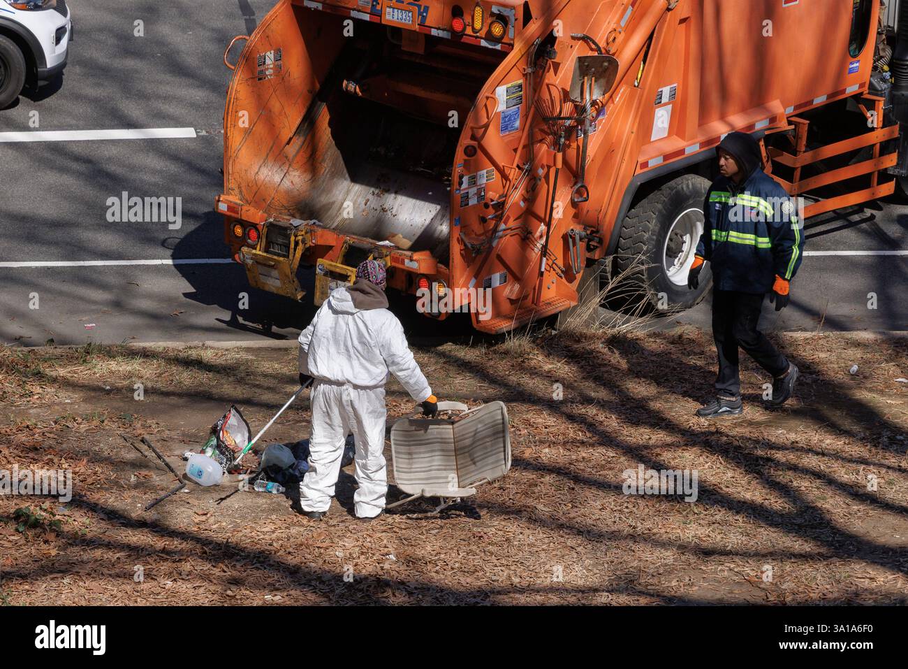 DC municipal workers and Metropolitan Police Department officers work to clear a homeless ...