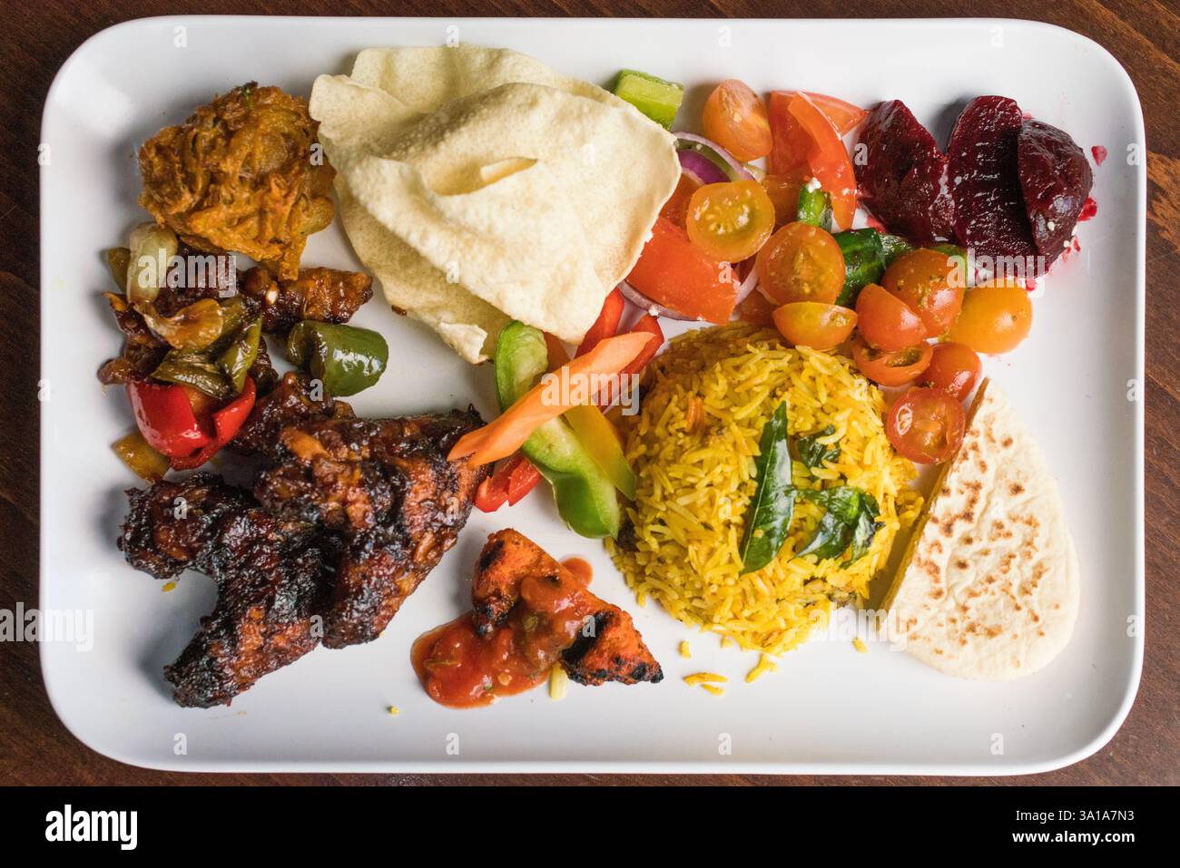 A platter of Indian food, including chicken tikka, biryani, pakoras ...