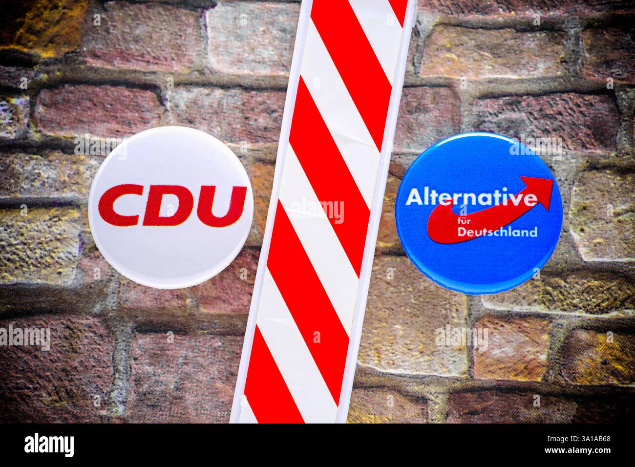 Party badges of CDU and AfD in front of wall with warning beacon ...