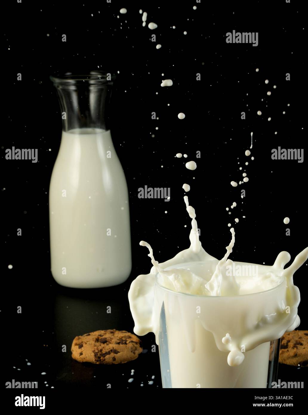 The milk is splashing out of the glass, creating a mess on the table. A ...