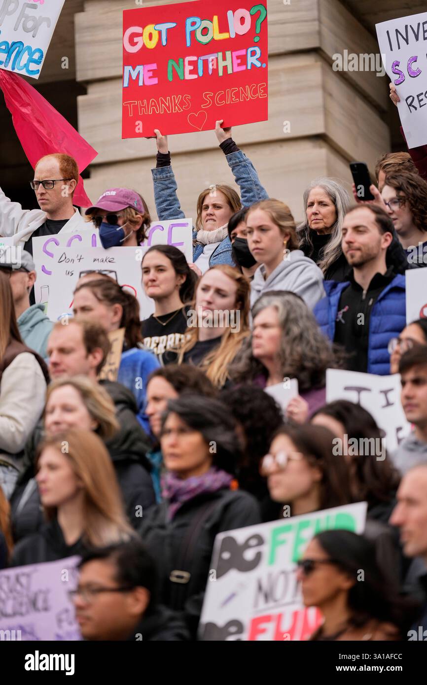 People hold signs during a Stand up for Science rally Friday, March 7 ...