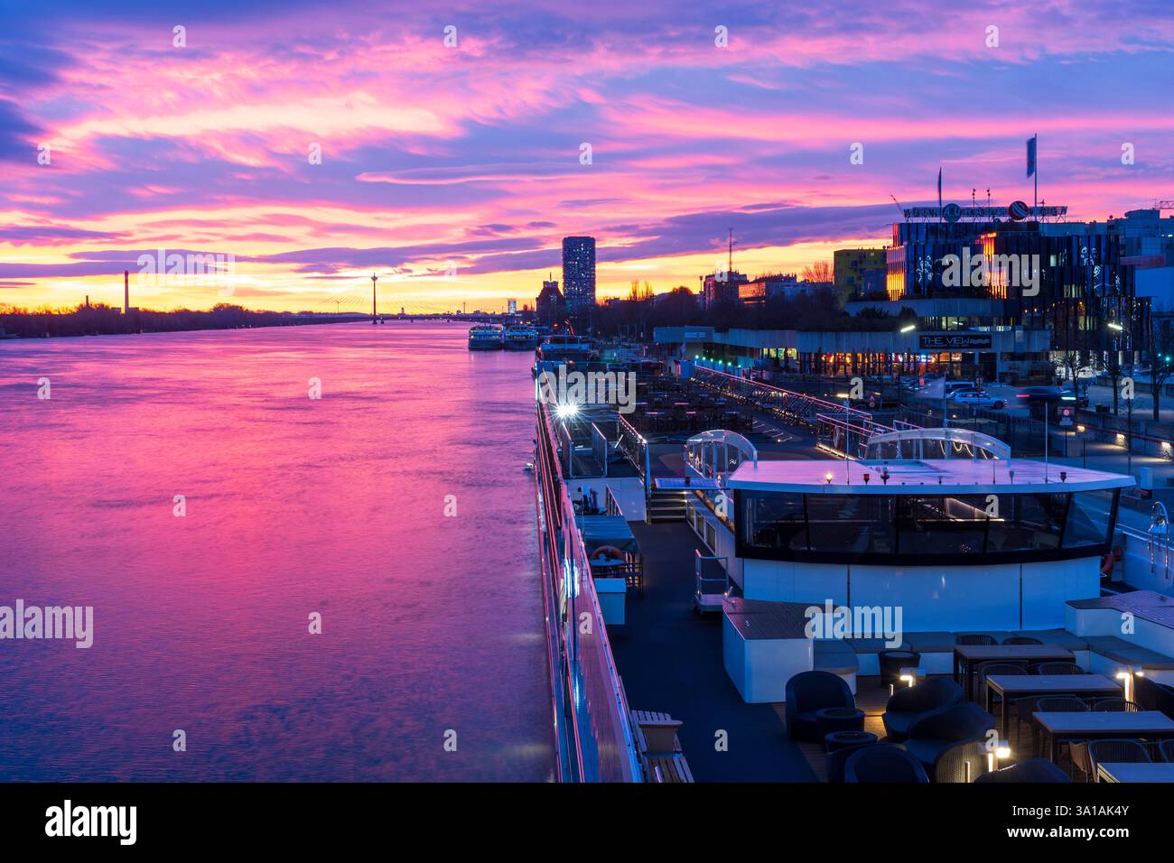 Vienna, fiery sunrise at river Donau (Danube), cruise ships at terminal ...