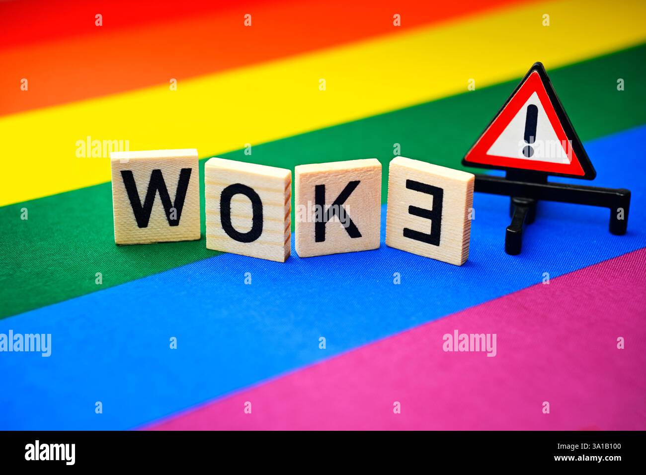 Woke lettering and warning sign on rainbow flag, wokeness and anti ...