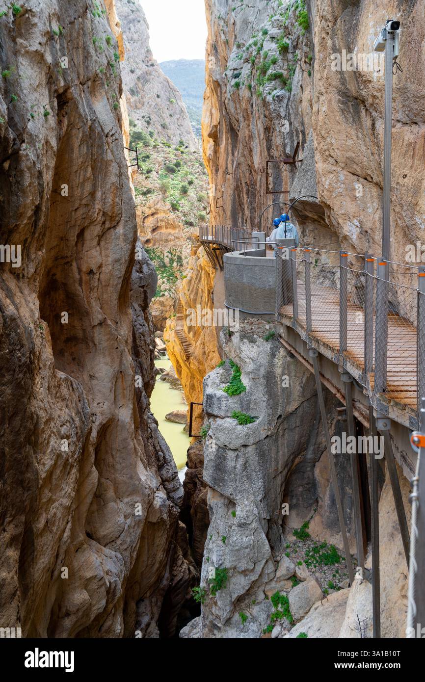 Hikers traverse the precarious wooden pathway, bolted into the steep ...