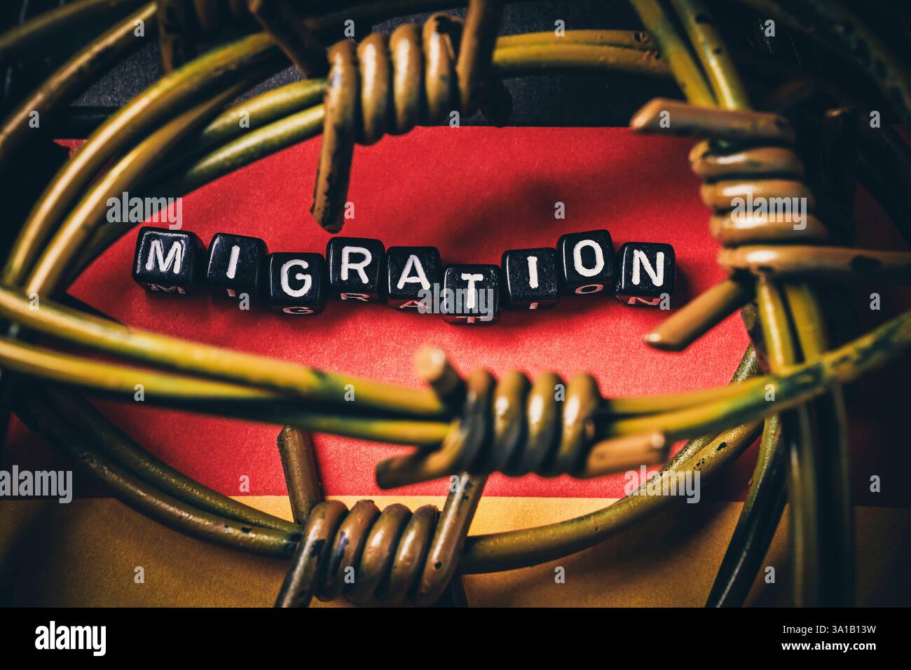 Writing Migration behind barbed wire on German flag, symbolic photo of ...