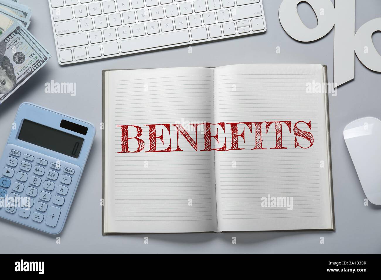 Benefits word in notebook, calculator, money, computer keyboard and mouse on grey table, top ...