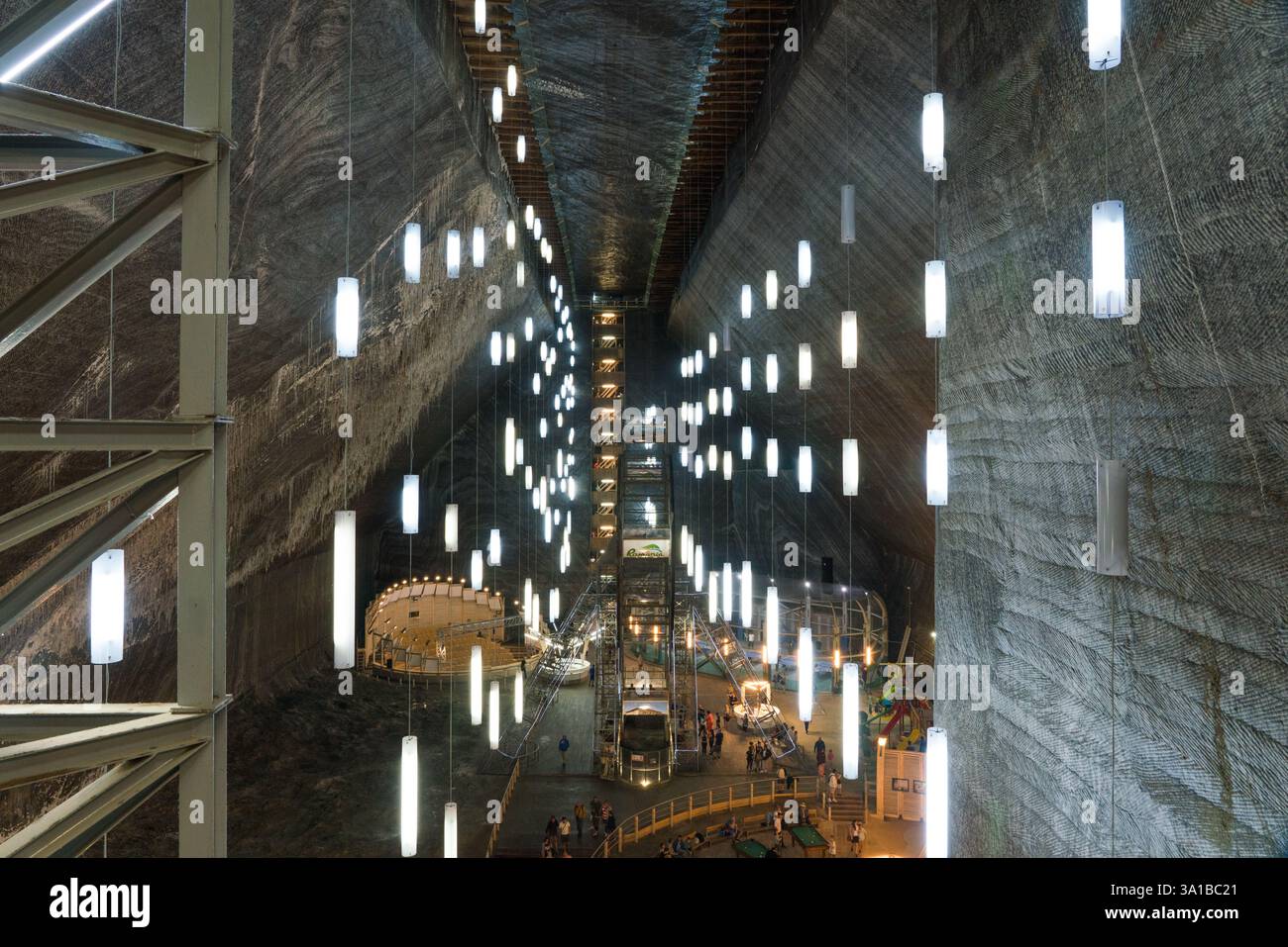 Visitors explore the Turda Salt Mine, Romania, a massive underground ...