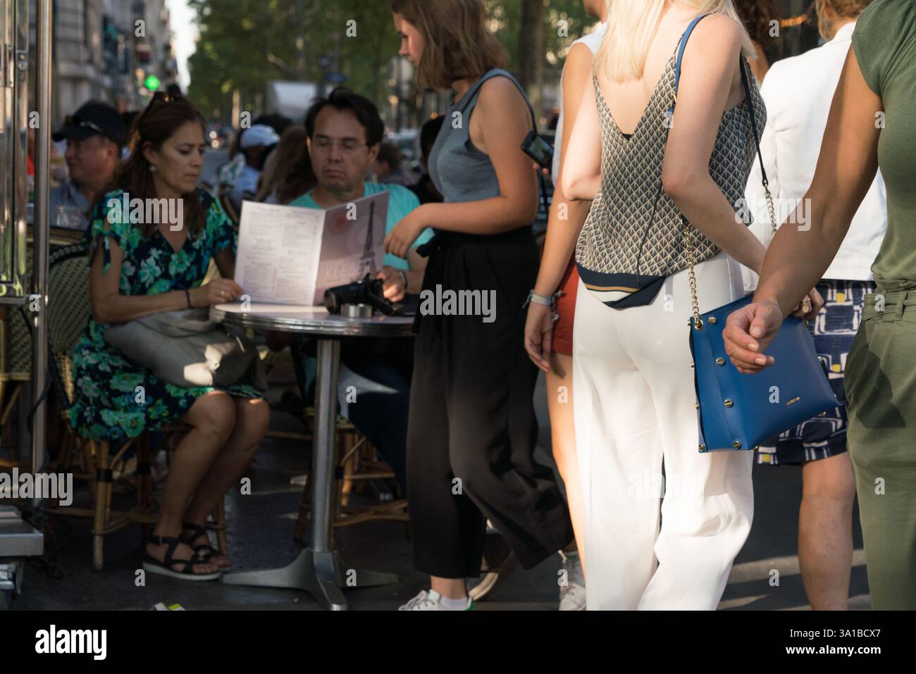 Tourists in Paris, near the Eiffel Tower, enjoying a cafe lunch. People ...