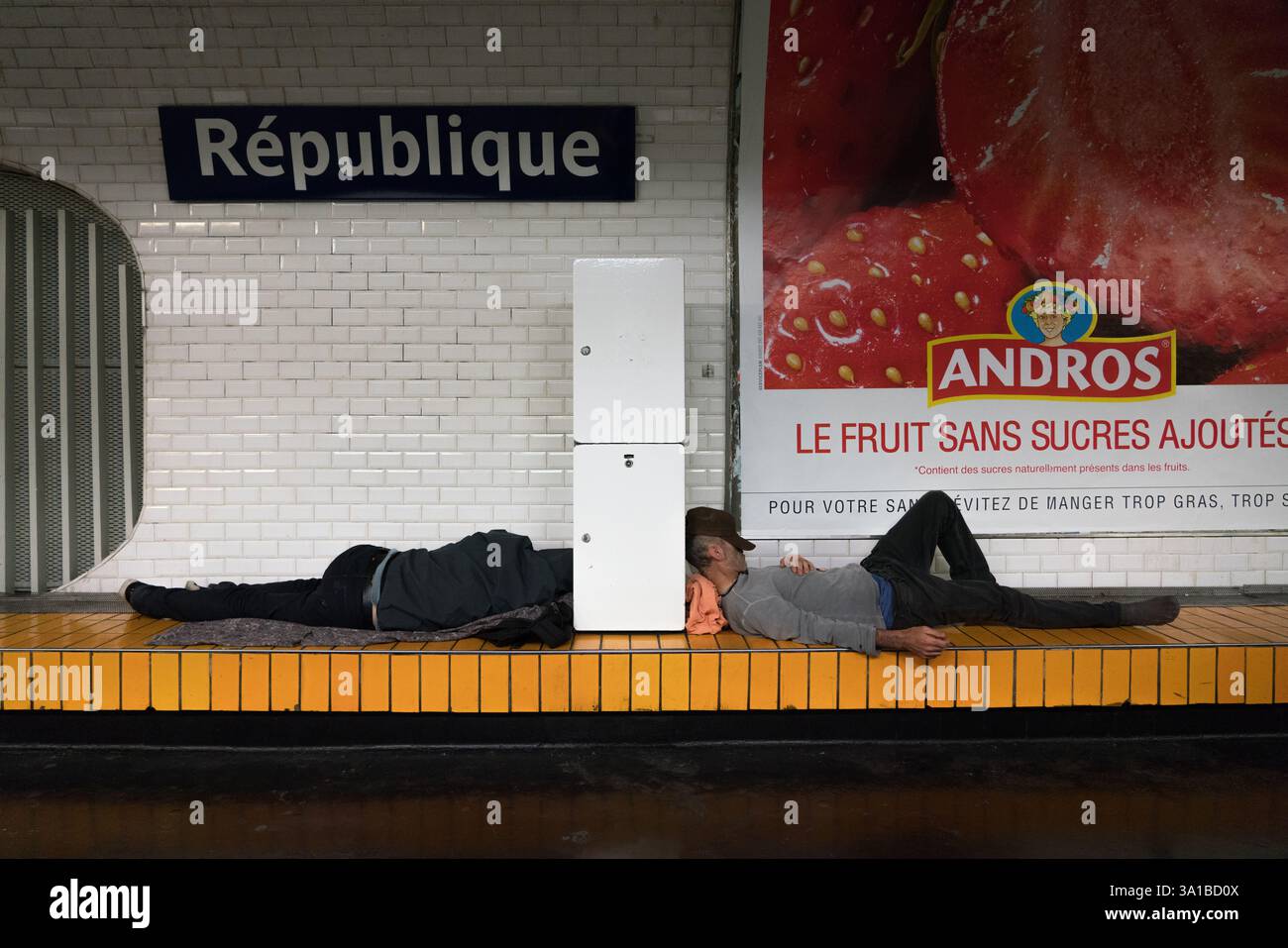 Homeless men sleep on the République metro station platform in Paris ...
