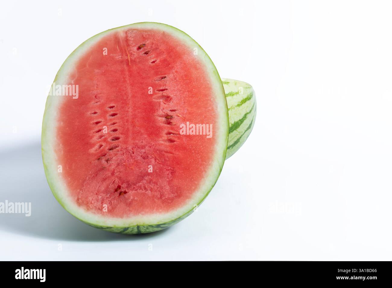 A freshly cut watermelon shows off its vibrant red interior and shiny ...