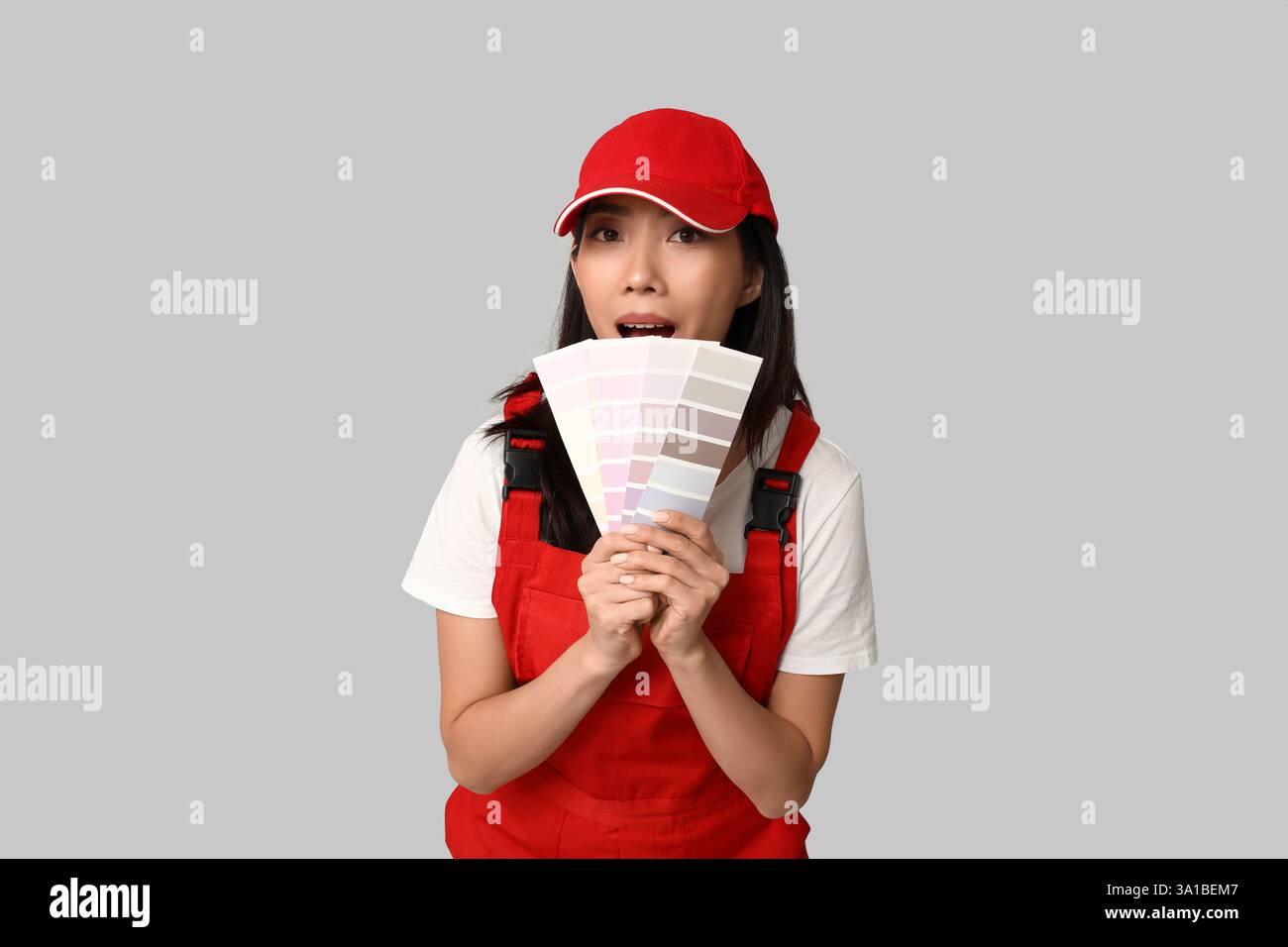 Female Asian shocked painter with paint color palettes on grey ...