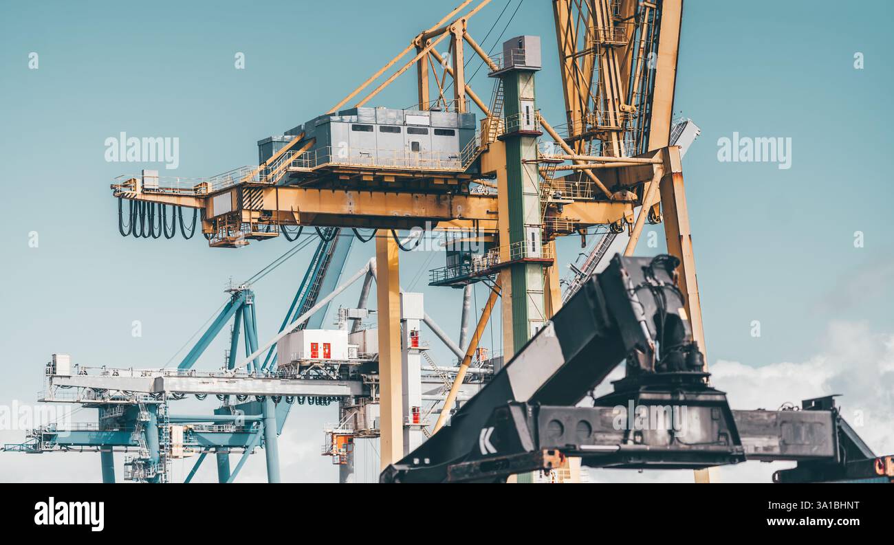 Industrial port cranes with steel structures, cables, and machinery ...