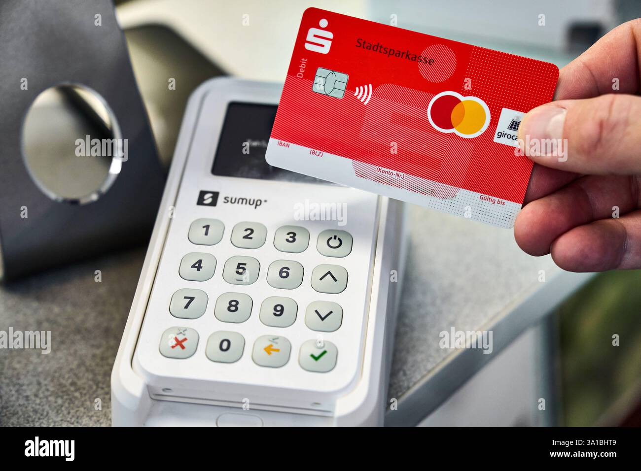 Augsburg, Bavaria, Germany - March 7, 2025: A man makes a contactless ...