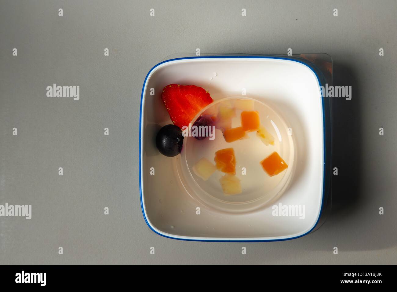 in flight healthy dessert, serving assorted fruit pudding, put on blue ...