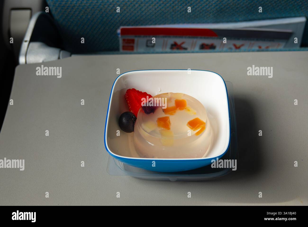in flight healthy dessert, serving assorted fruit pudding, put on blue ...