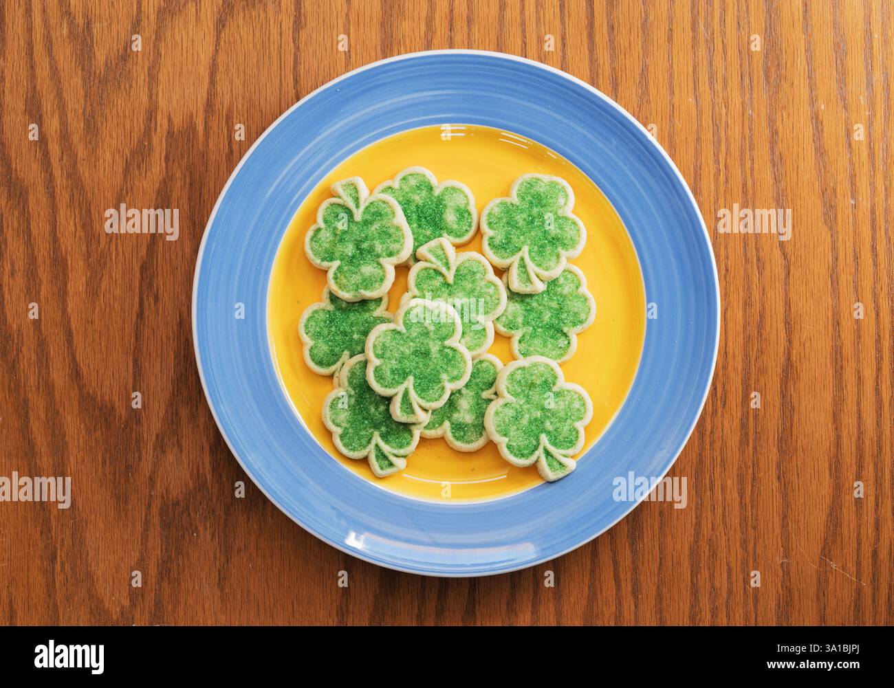 flat lay shamrock green sprinkle sugar cookies on yellow and blue plate ...