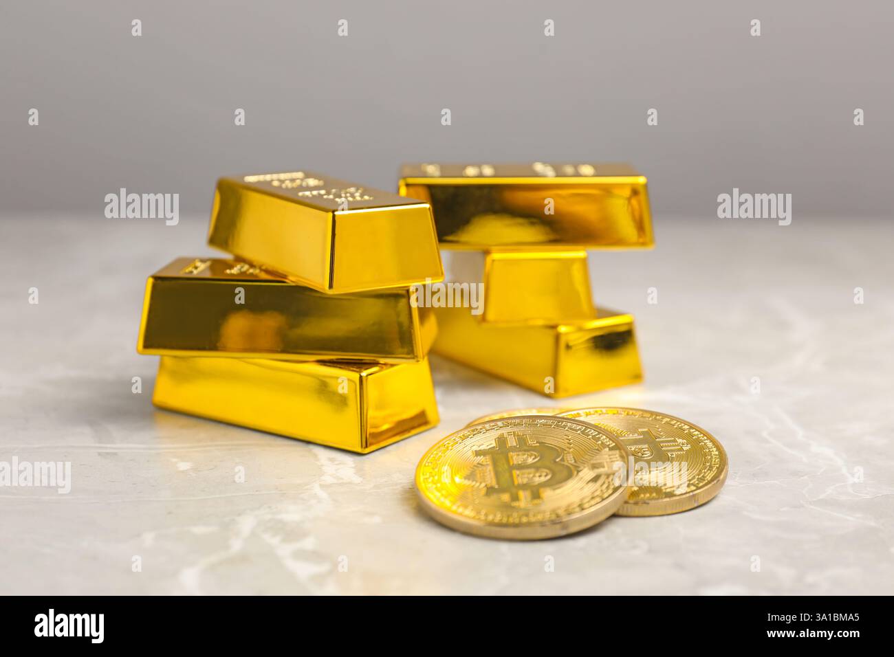 Gold bars and coins on grey marble table, closeup Stock Photo - Alamy