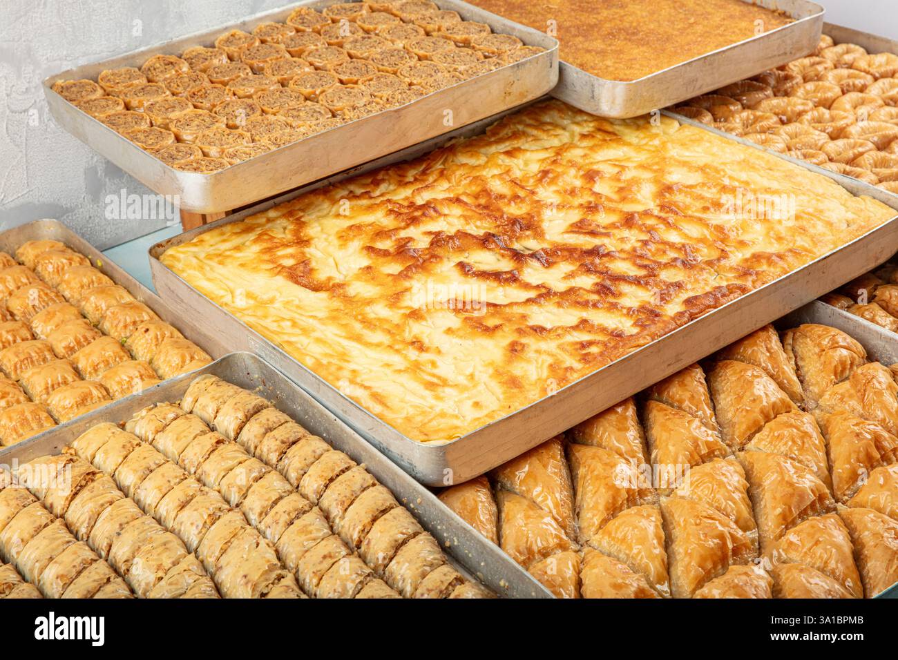 Mixed baklava varieties lined up on trays and tray water borek ...