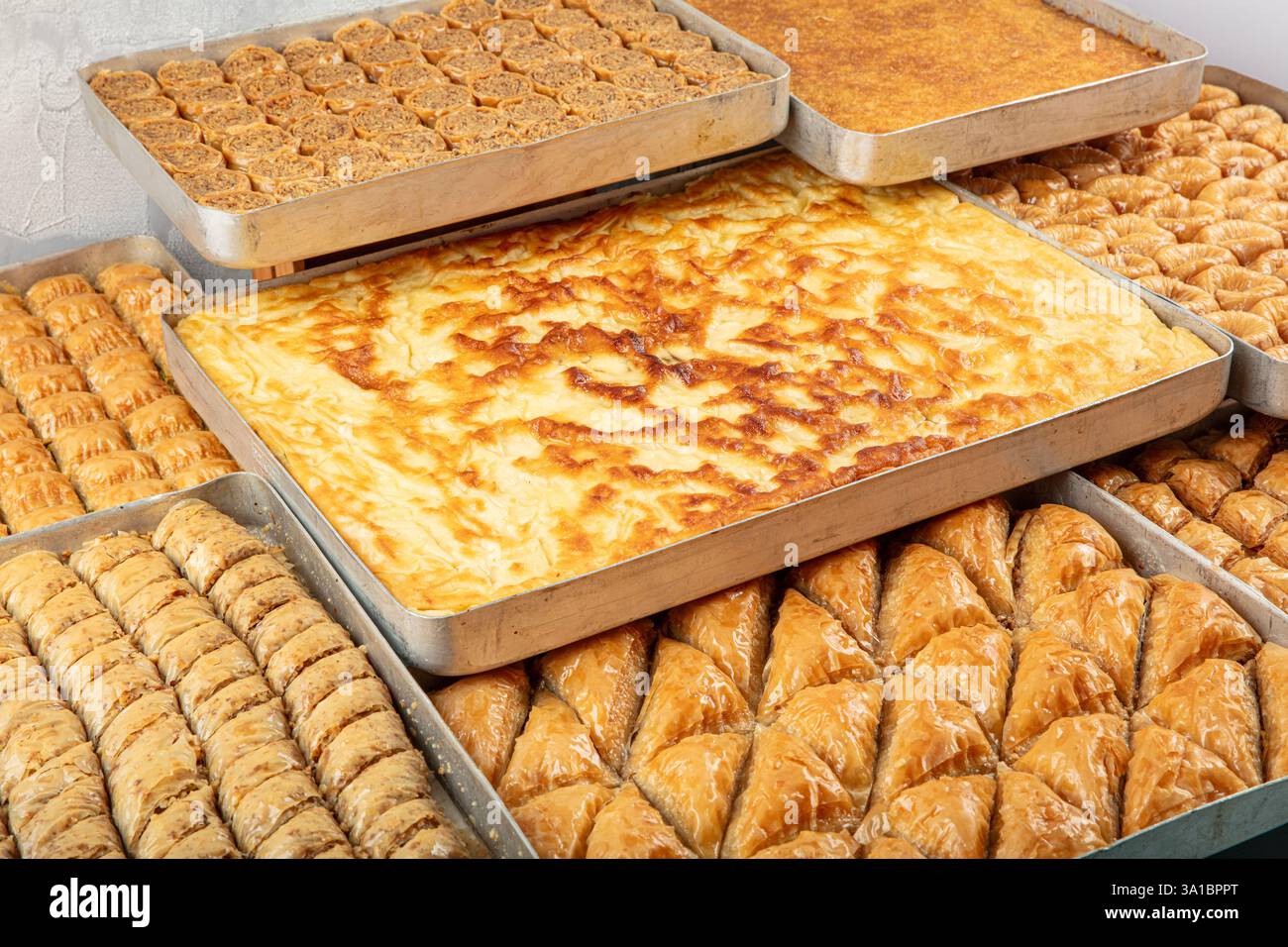 Mixed baklava varieties lined up on trays and tray water borek ...