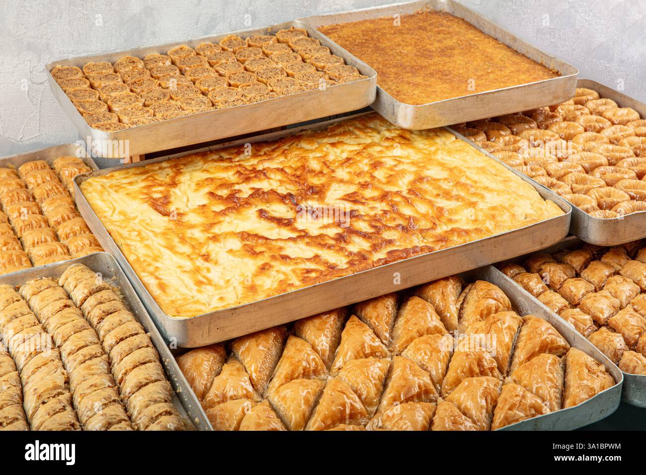 Mixed baklava varieties lined up on trays and tray water borek ...