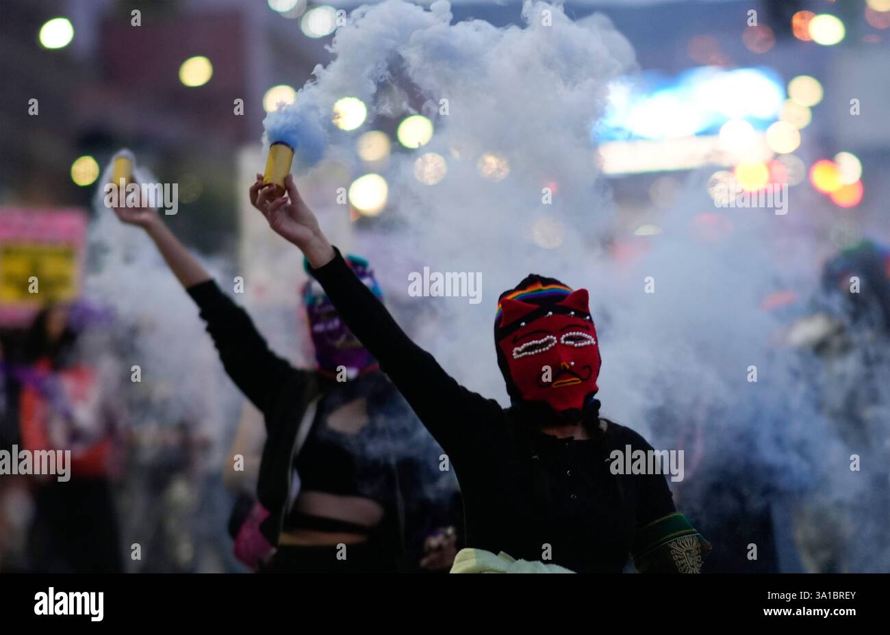 Women hold smoke cans during a march marking International Women's Day ...