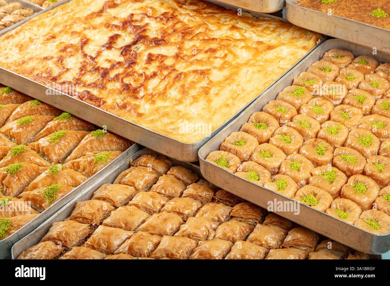 Mixed baklava varieties lined up on trays and tray water borek ...