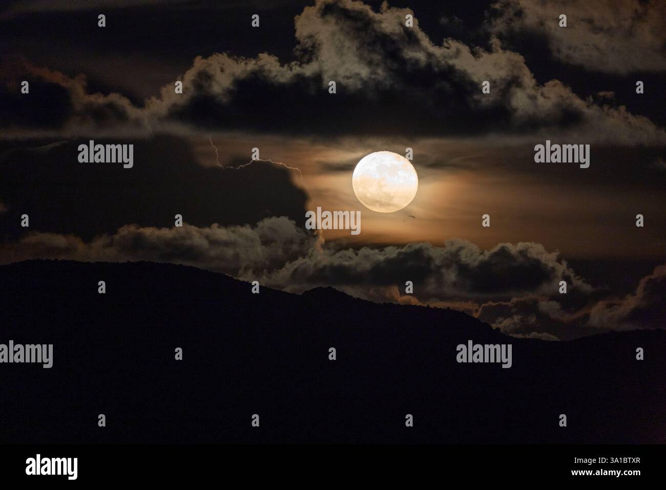 Rising moon behind clouds hi-res stock photography and images - Alamy