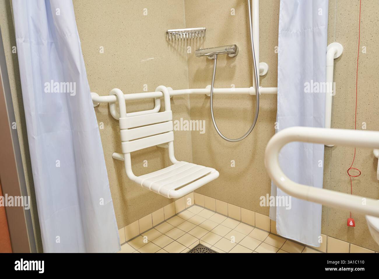 A shower room with a plastic chair in a hospital, designed for the ...