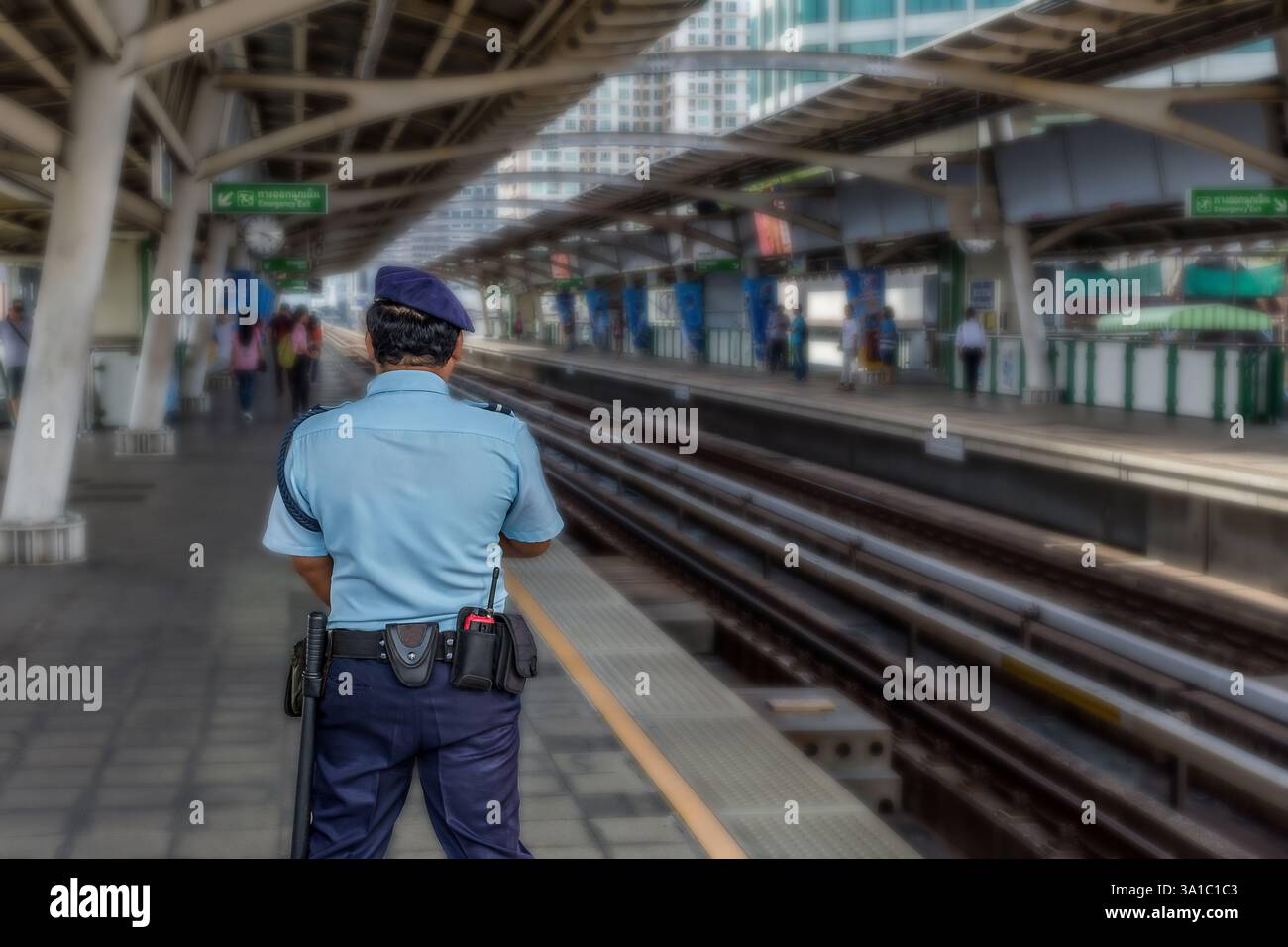 Security guard on BTS skytrain train runs in Bangkok. Many people in ...