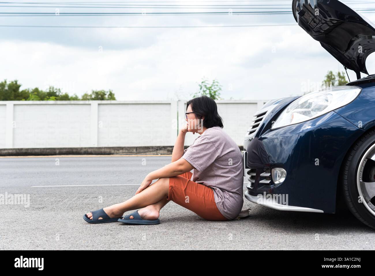 Asian woman 40s alone driver checking a car engine for fix and repair ...