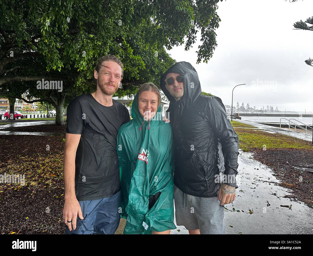 Otis Matvejs, Alicia Manning and Jeremie Manning walk in the rain at ...