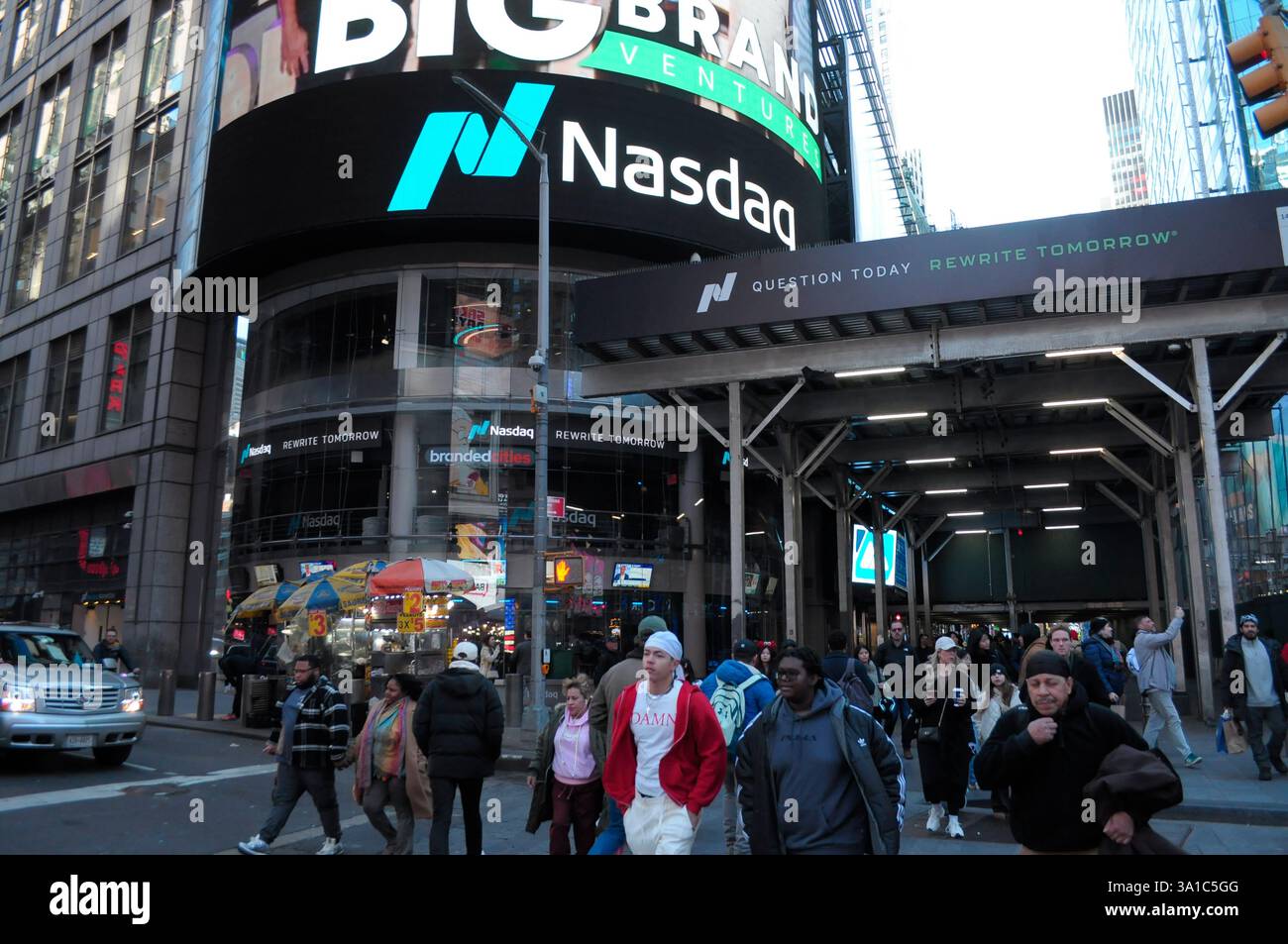 People walk past the Nasdaq MarketSite Times Square event space in ...
