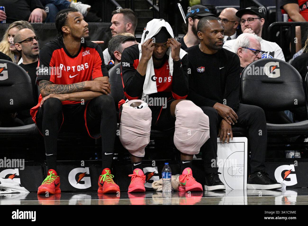 Toronto Raptors guard Immanuel Quickley, center, sits on the bench ...