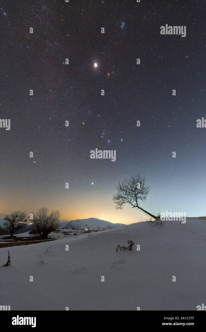 Winter constellations and planet Jupiter over a snowy landscape. Photographed in the Alborz ...