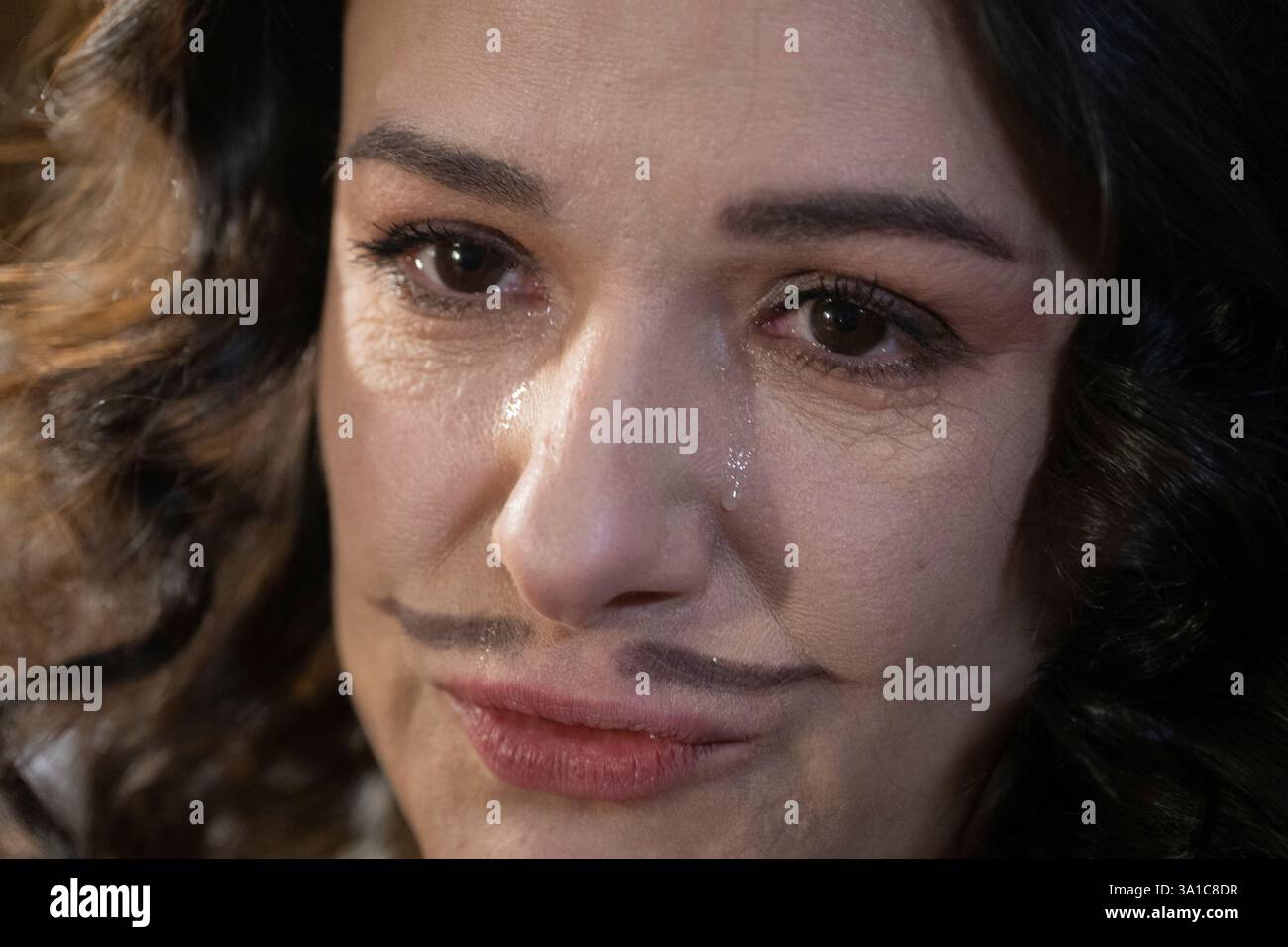 Actress Ruslana Ostapko, wearing a painted moustache, cries as the ...