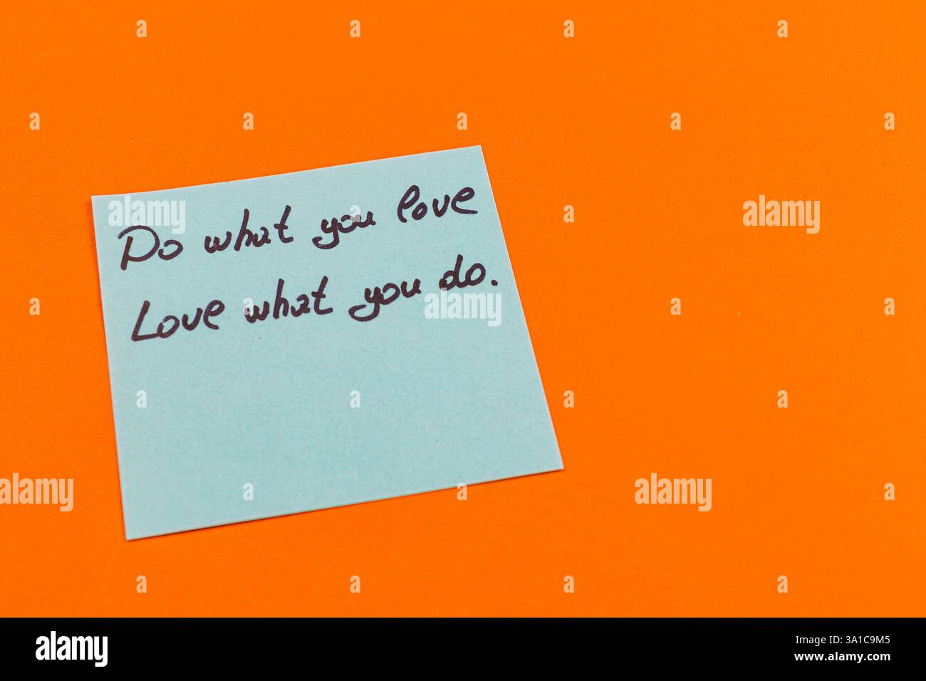 A handwritten note on a blue sticky paper displays motivational phrases ...