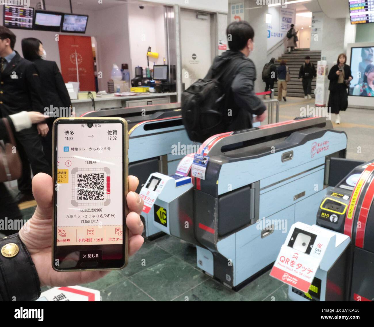 Passengers board trains by holding the QR code displayed on their ...