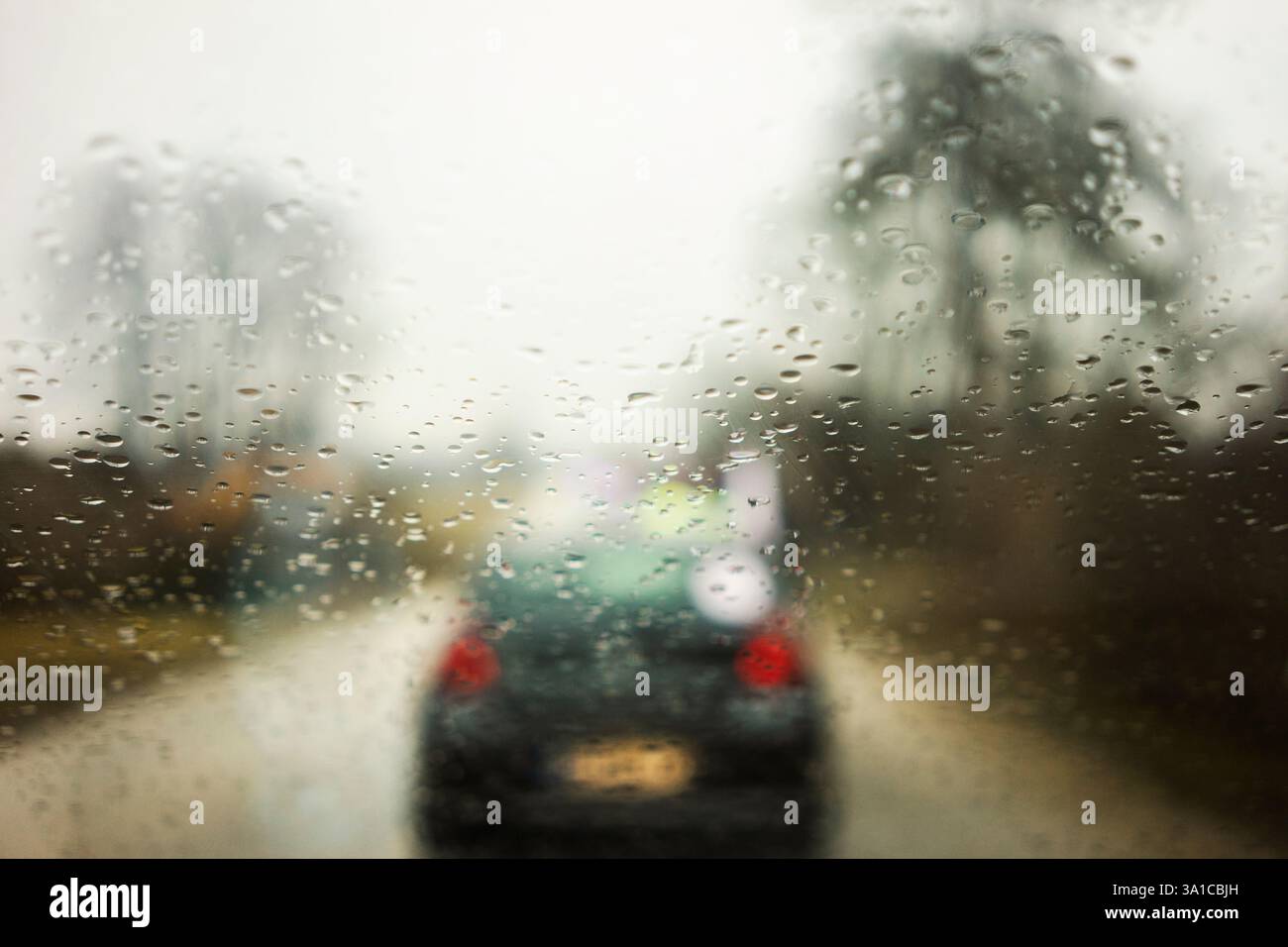 Car windshield during rainy weather with focus on raindrops Stock Photo ...