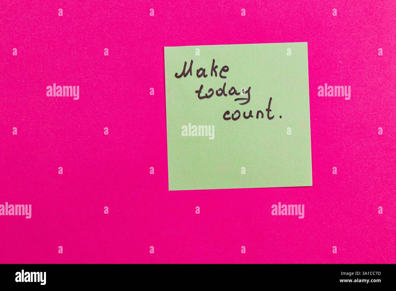 A small light green sticky note with handwritten motivational words ...