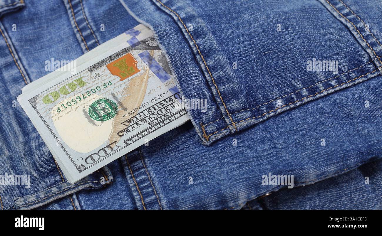 Stack of us dollars in the back pocket of blue jeans Stock Photo - Alamy