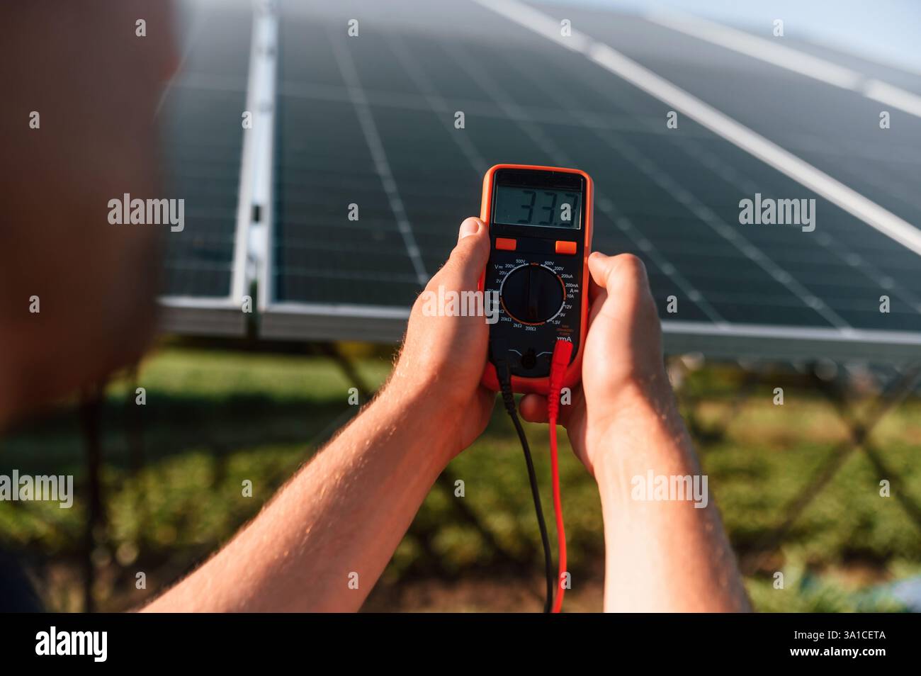 Measuring the electricity by using device. Man is doing operating and ...