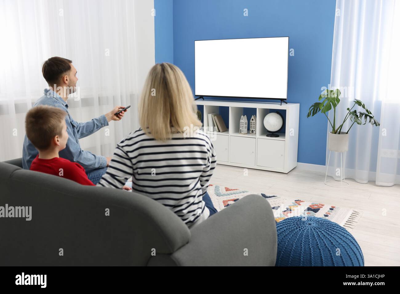 Happy family watching tv together at home Stock Photo - Alamy