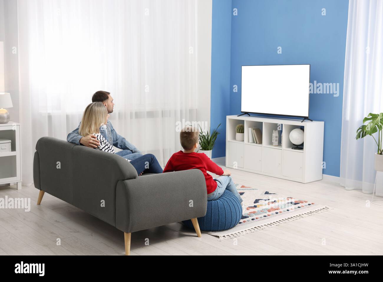 Happy family watching tv together at home Stock Photo - Alamy