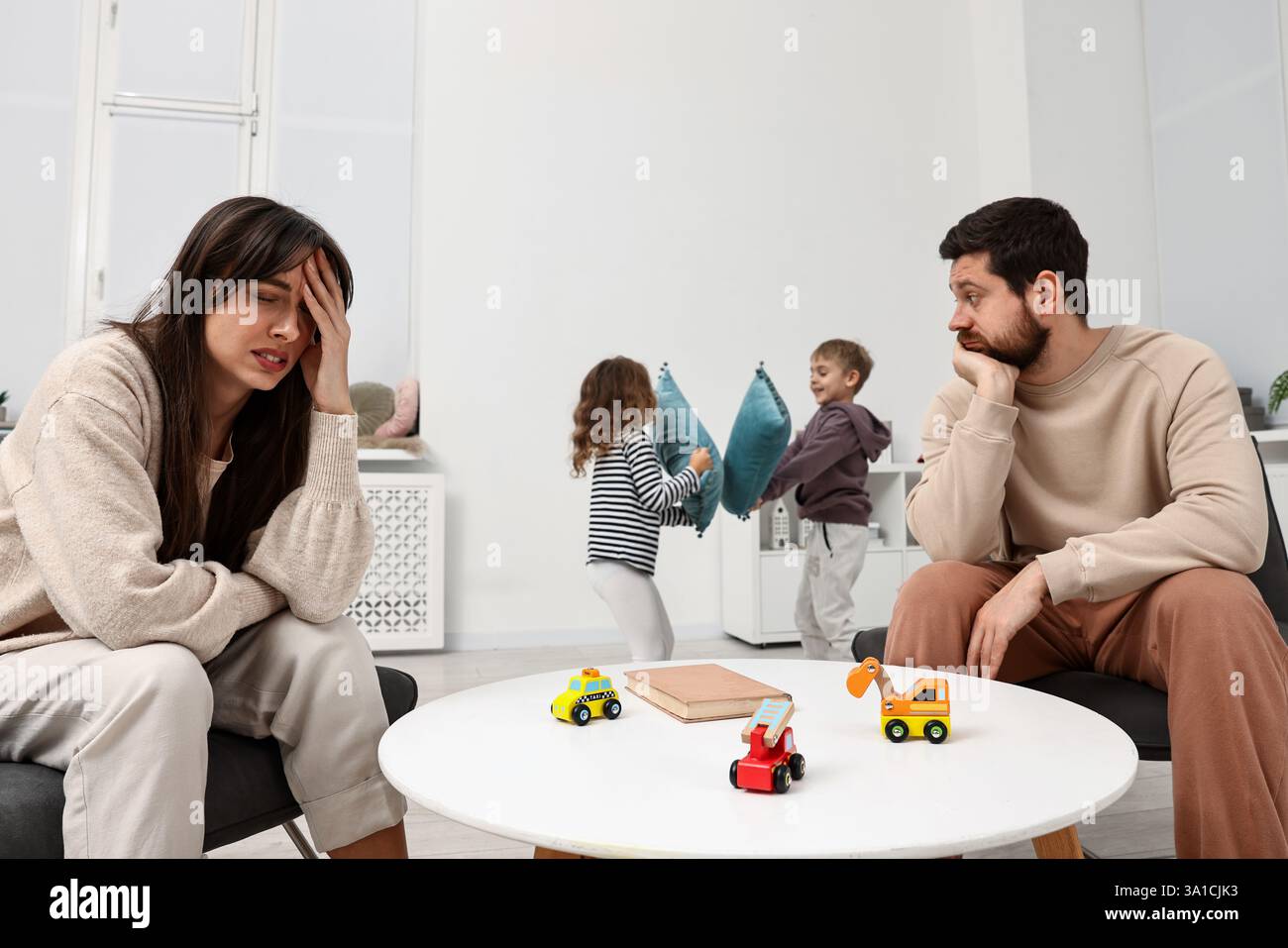 Overwhelmed parents and their naughty children at home Stock Photo - Alamy