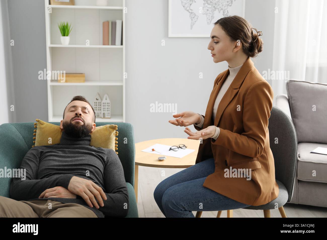 Psychologist working with patient during hypnosis session indoors Stock ...