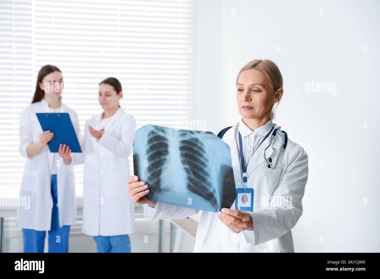 Doctor examining chest x-ray in clinic. Medical assistants with ...